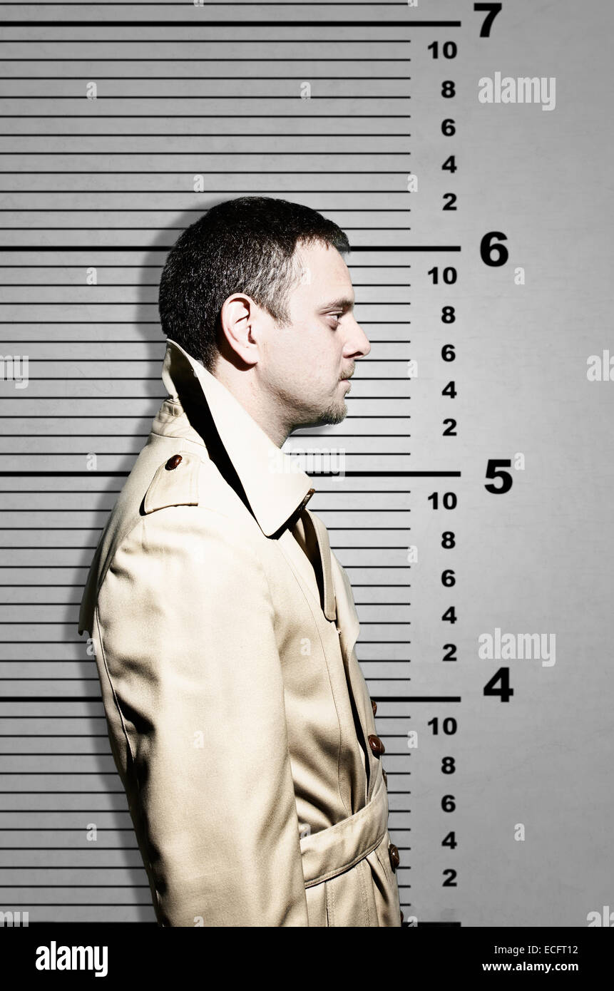 Killer standing on height ruler for photo in prison Stock Photo - Alamy