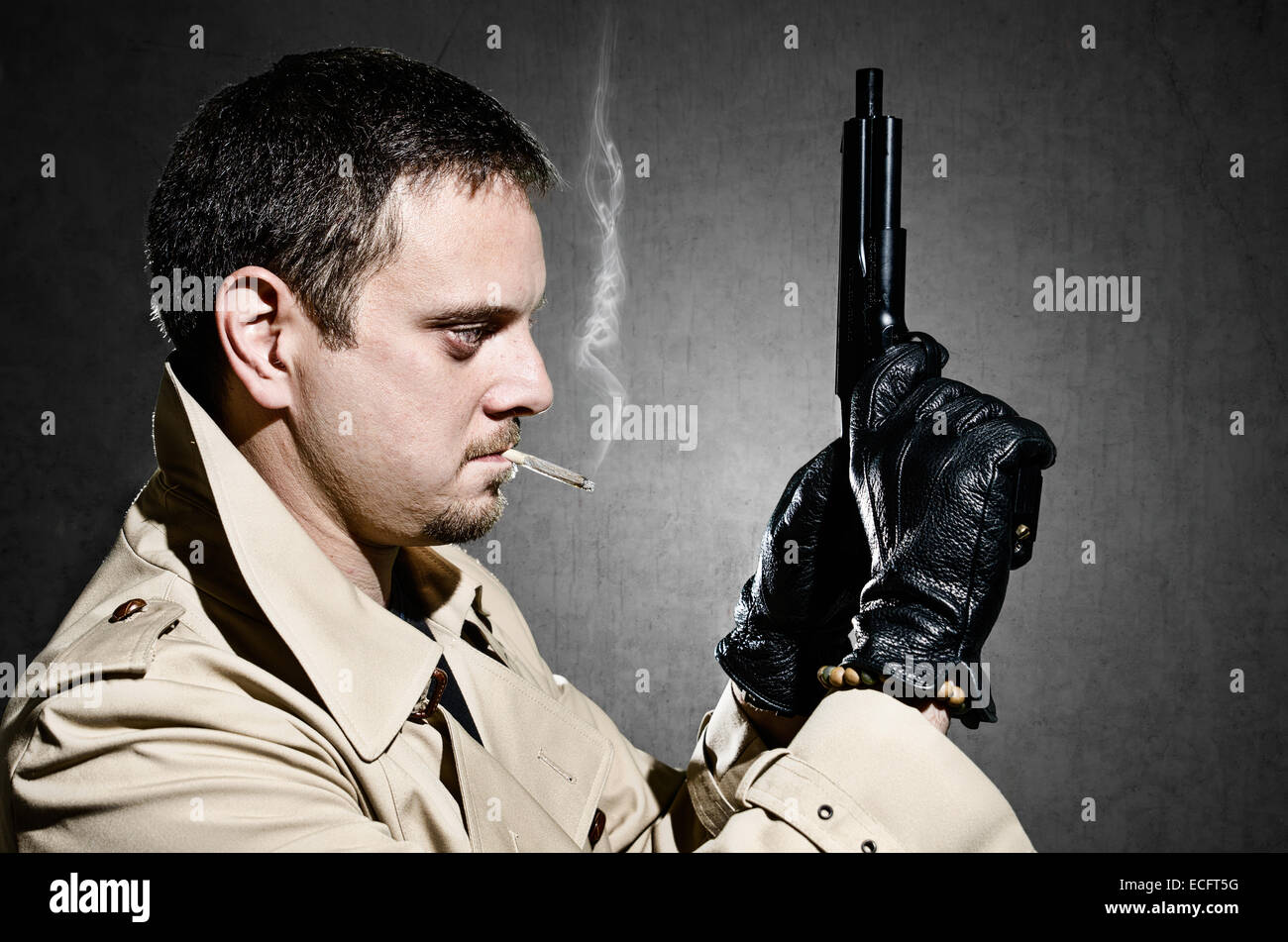 Killer standing on dark background recharging gun Stock Photo - Alamy