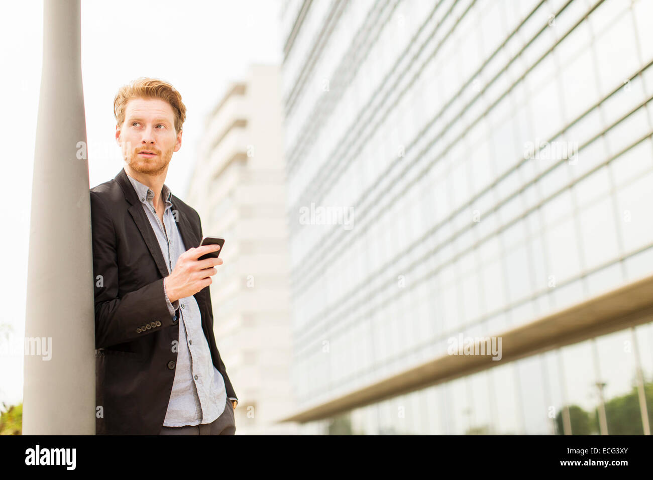 Young man on the street with mobile phone Stock Photo - Alamy