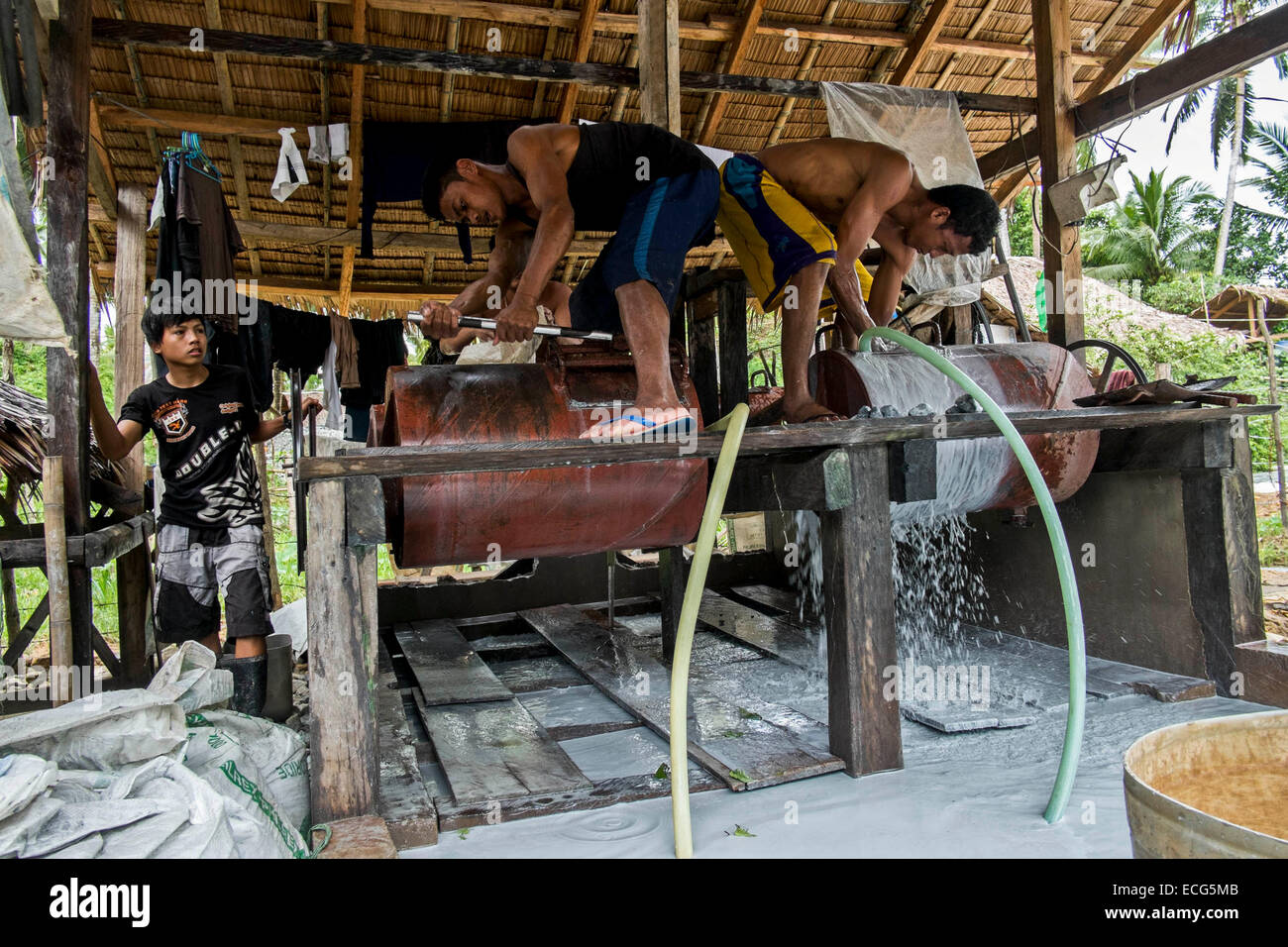 A minor miner watches his co-workers washes the ball mills and prepares ...