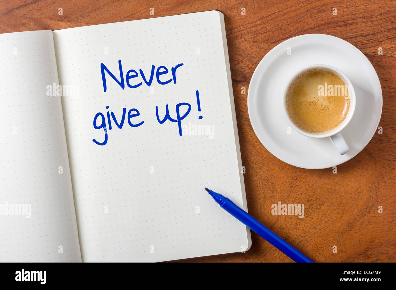 Notebook on a desk - Never give up Stock Photo - Alamy
