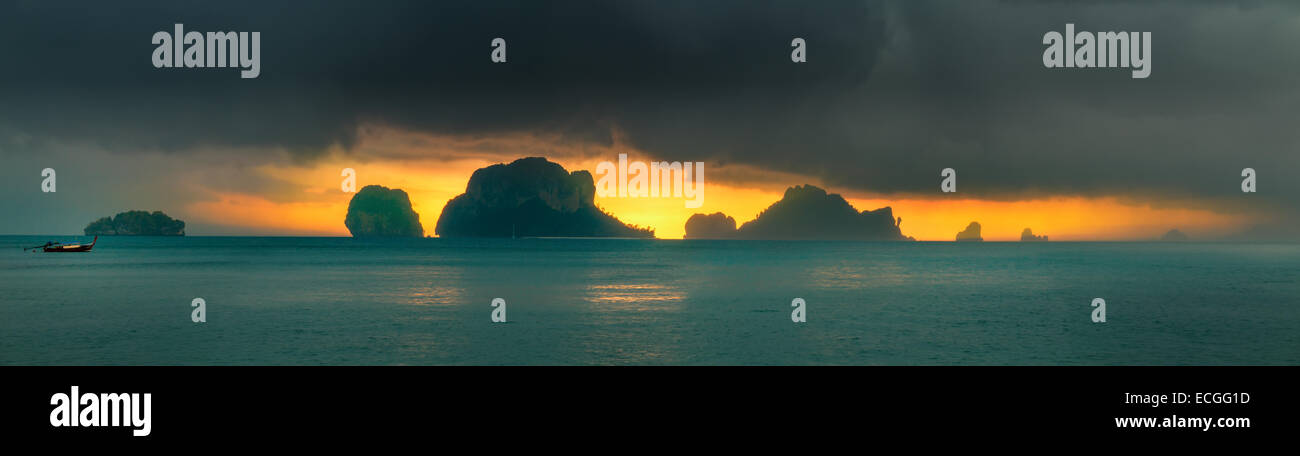 Dramatic sunset rays through a cloudy dark sky and mountains over the ...