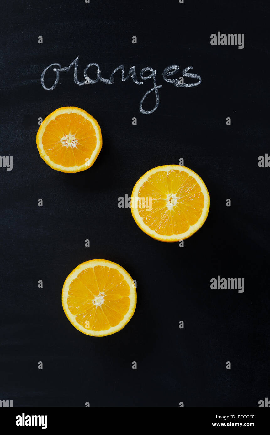 Orange fruits over black chalkboard with handwritten "oranges" word ...