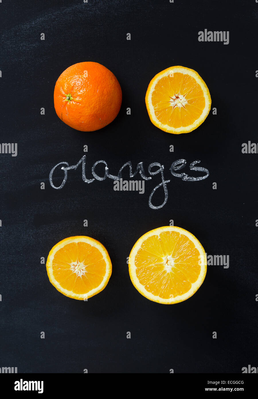 Orange fruits over black chalkboard with handwritten "oranges" word ...