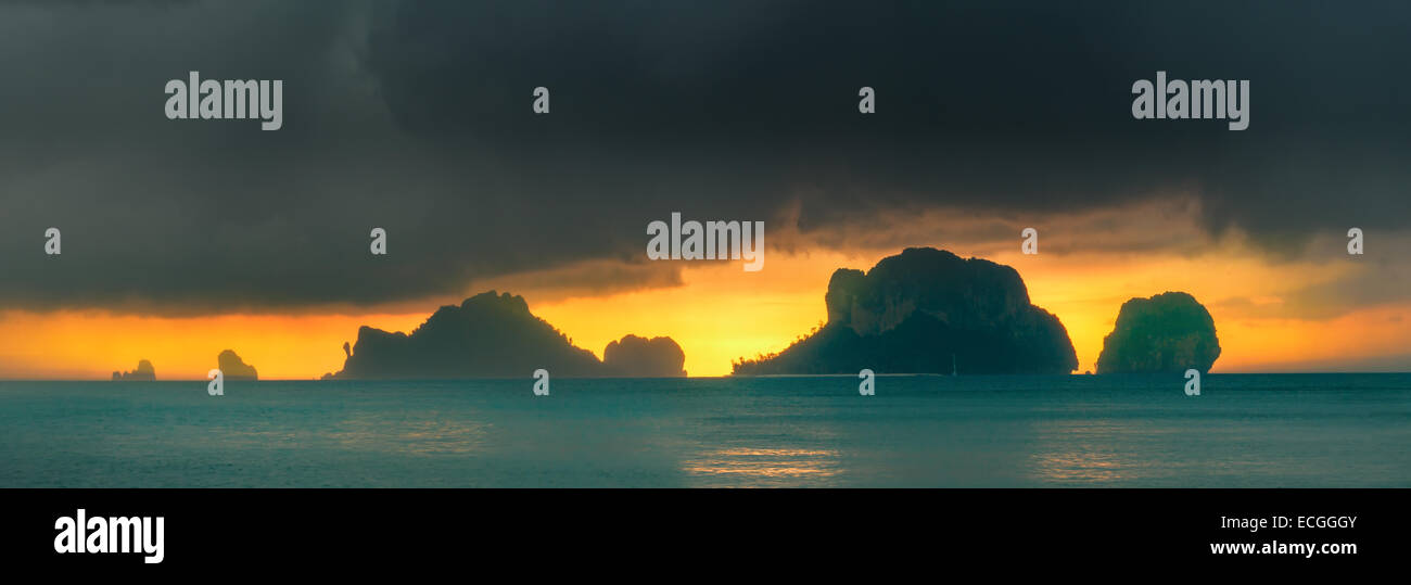 Dramatic sunset rays through a cloudy dark sky and mountains over the ...