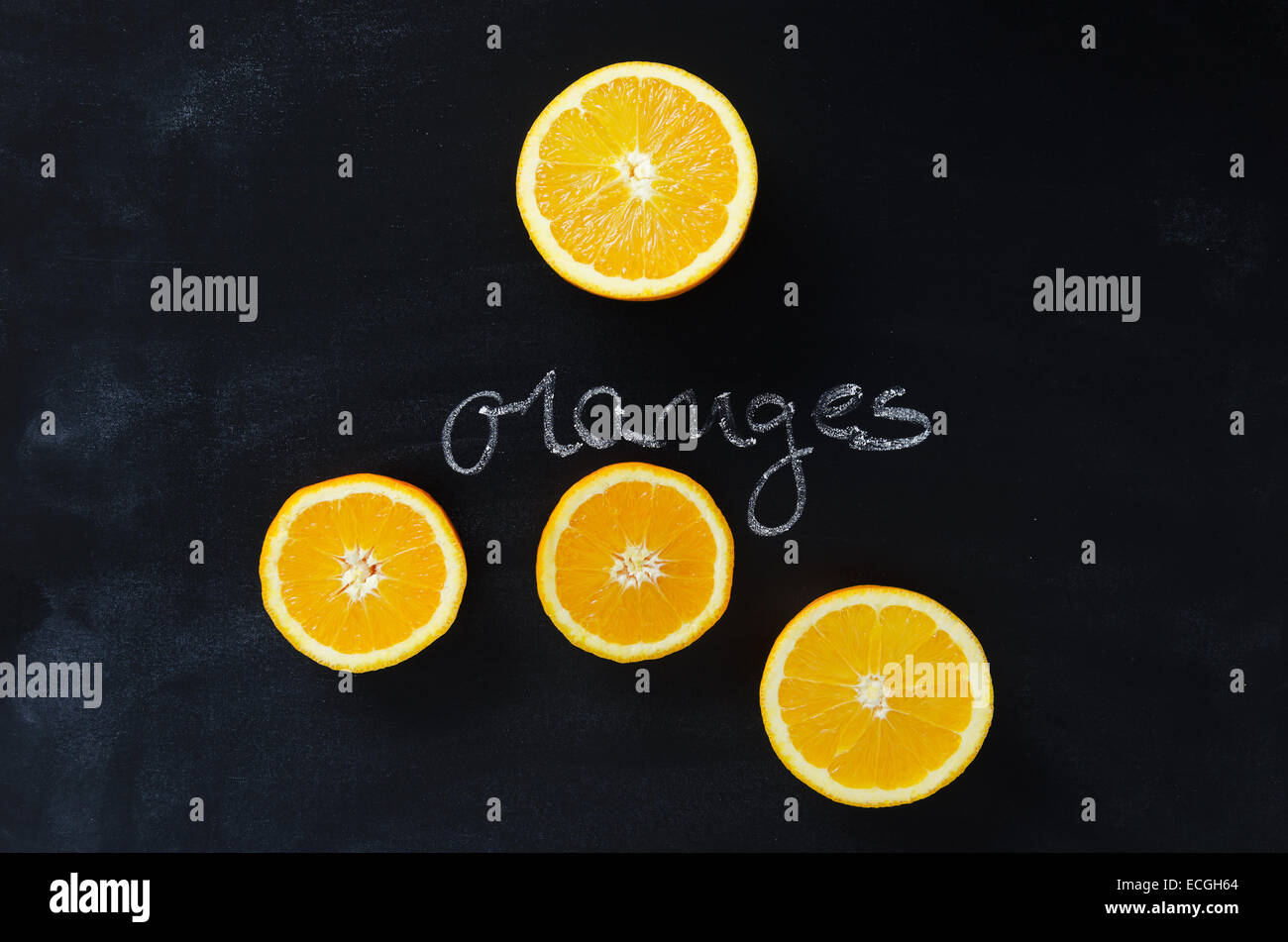 Orange fruits over black chalkboard with handwritten "oranges" word ...