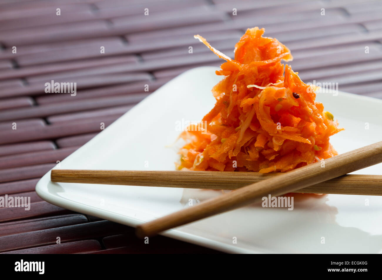 small serving of fermented carrots served on a small white plate with ...