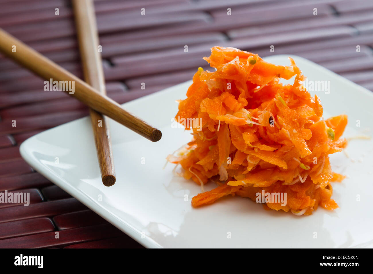 small serving of fermented carrots served on a small white plate with ...
