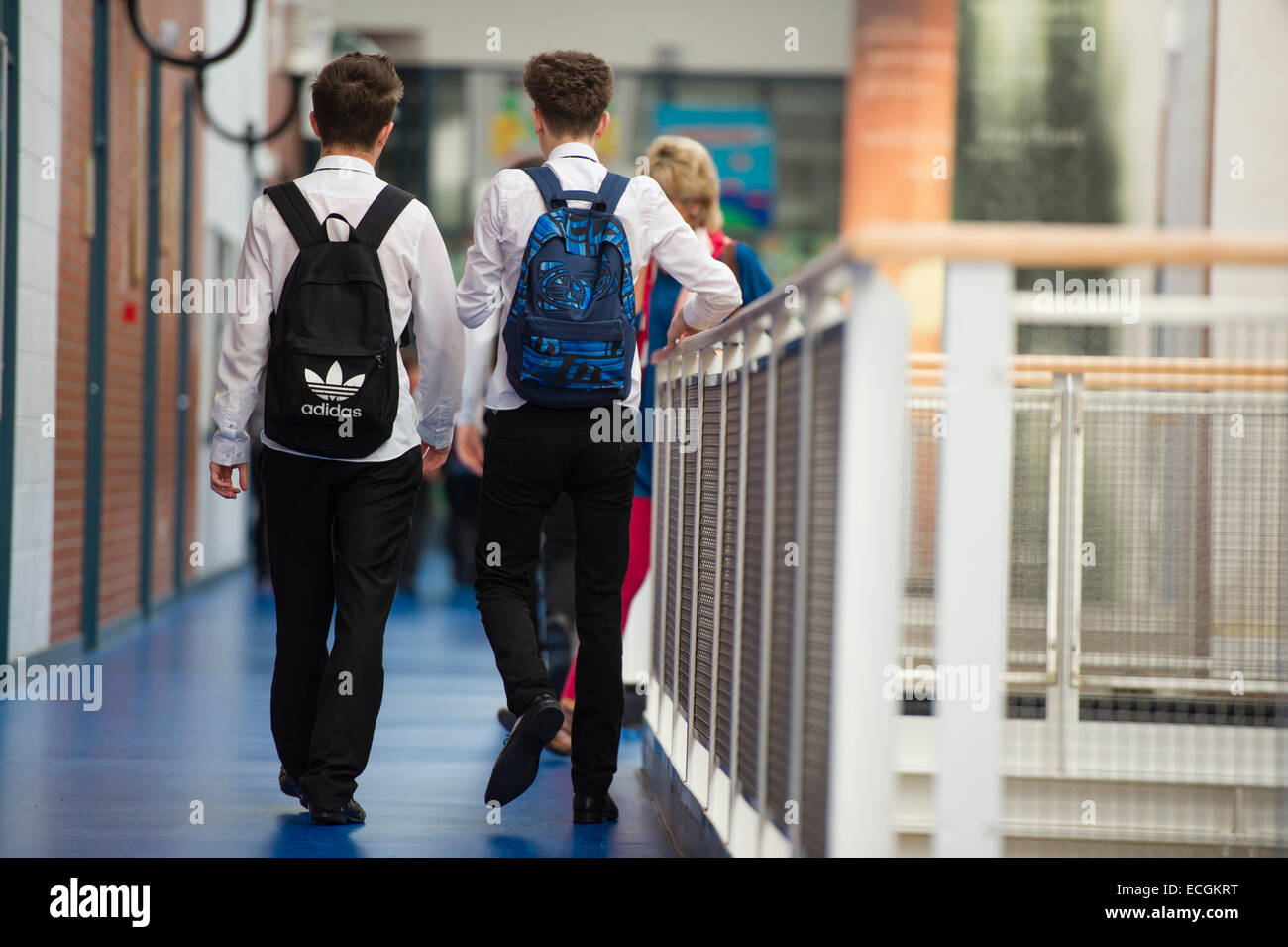 Two teenage boys walking to their classes lessons in a Secondary school ...