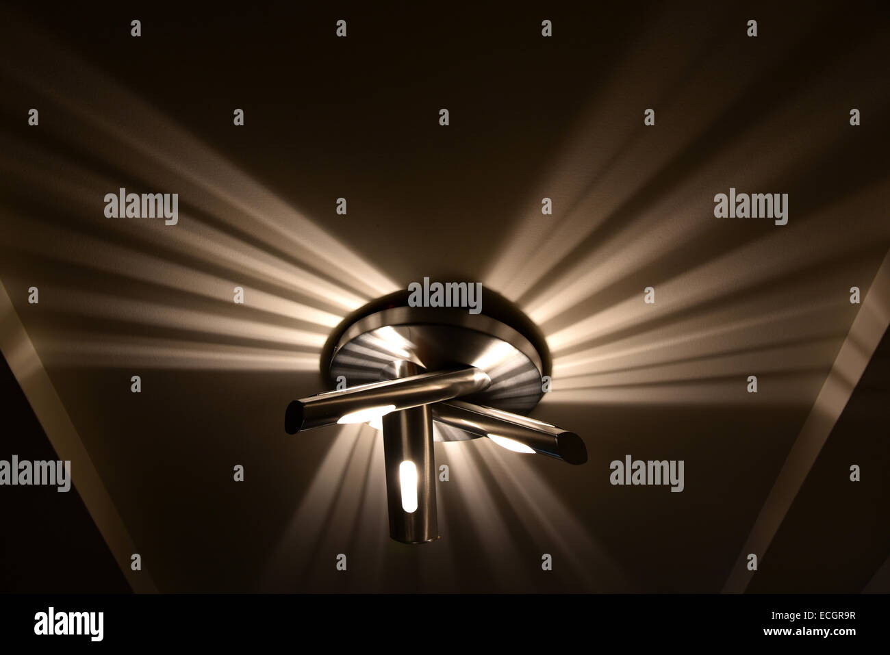 A modern light throws beams of light onto the ceiling Stock Photo - Alamy