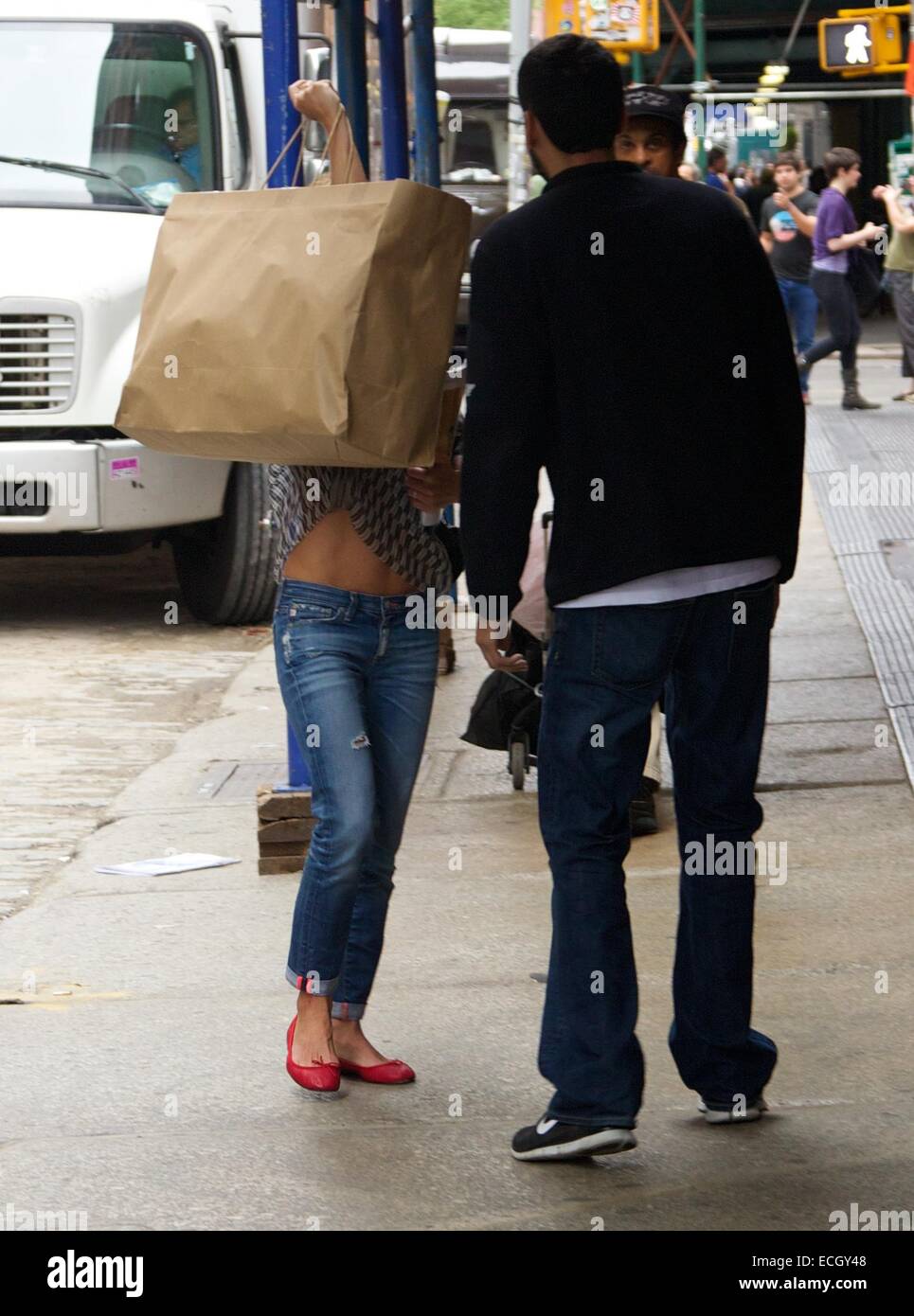 Kelly Ripa displays her toned midriff as she holds up an oversized ...