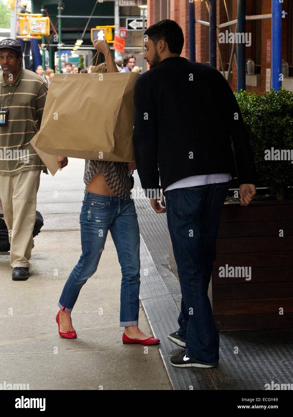 Kelly Ripa displays her toned midriff as she holds up an oversized ...