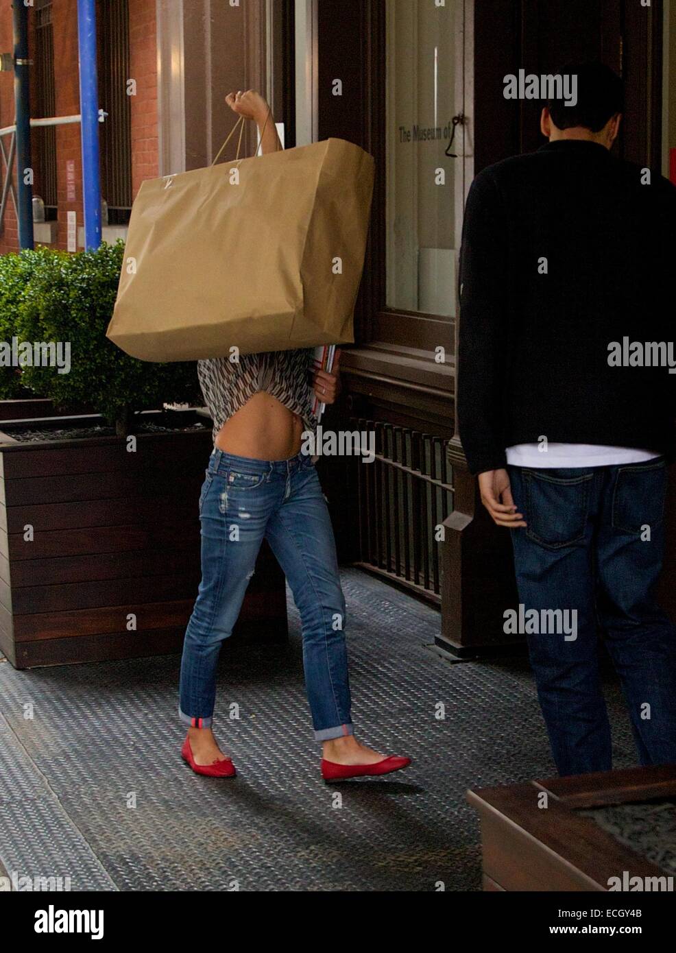 Kelly Ripa displays her toned midriff as she holds up an oversized ...