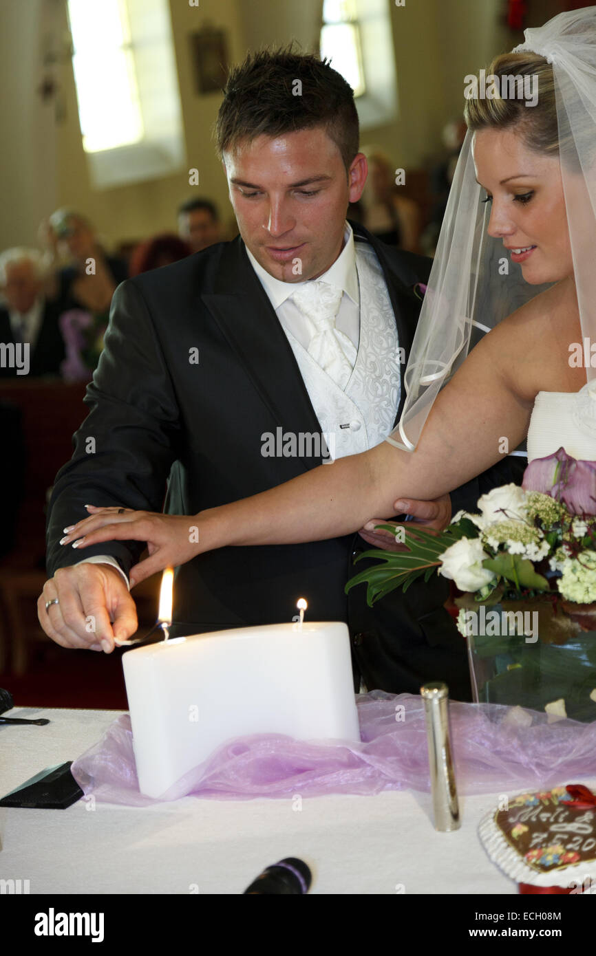 bridal couple in church igniting wedding candle Stock Photo - Alamy