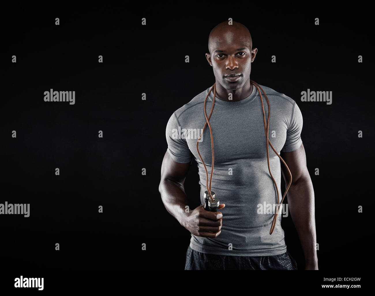 Handsome muscular man with jumping rope on black background. Fit ...