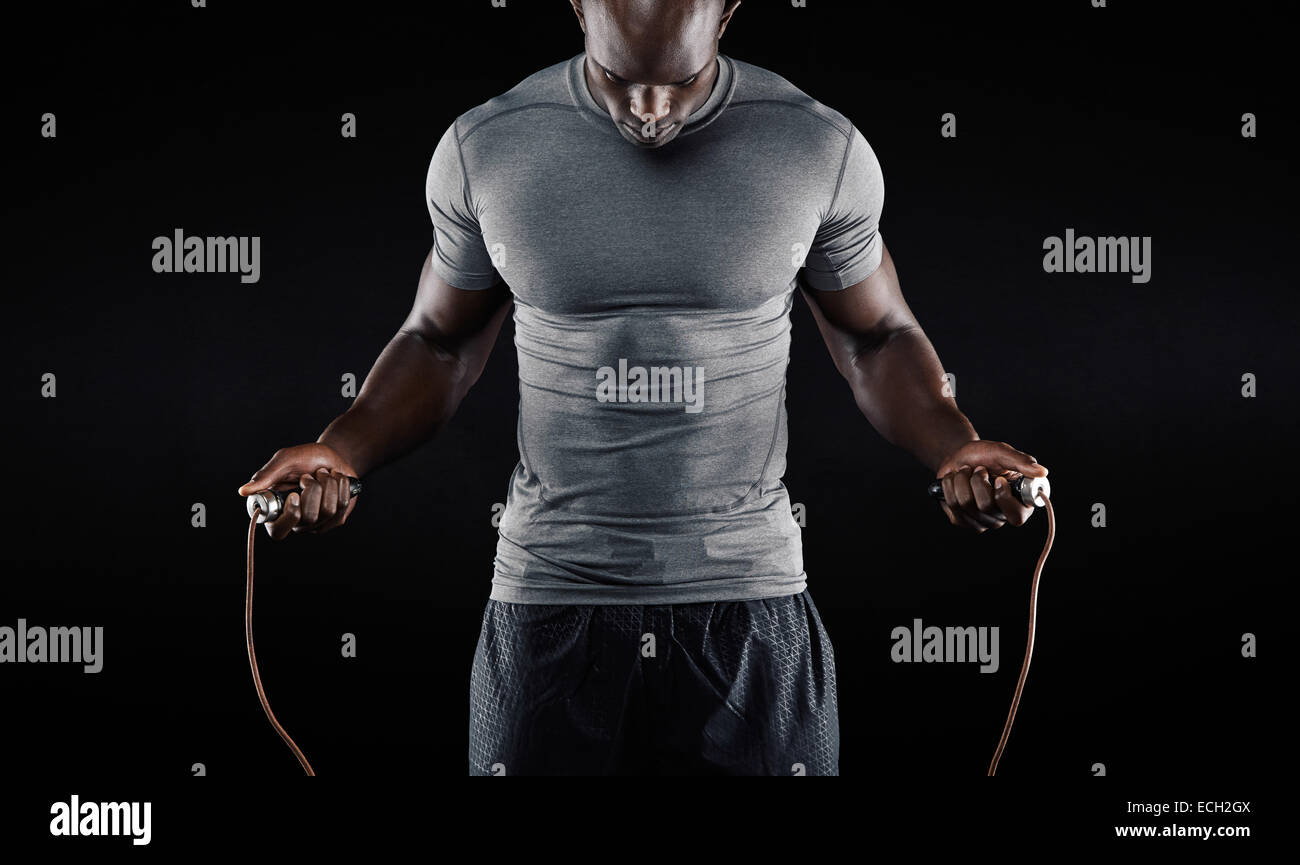 Muscular man skipping rope. Portrait of muscular young man exercising ...