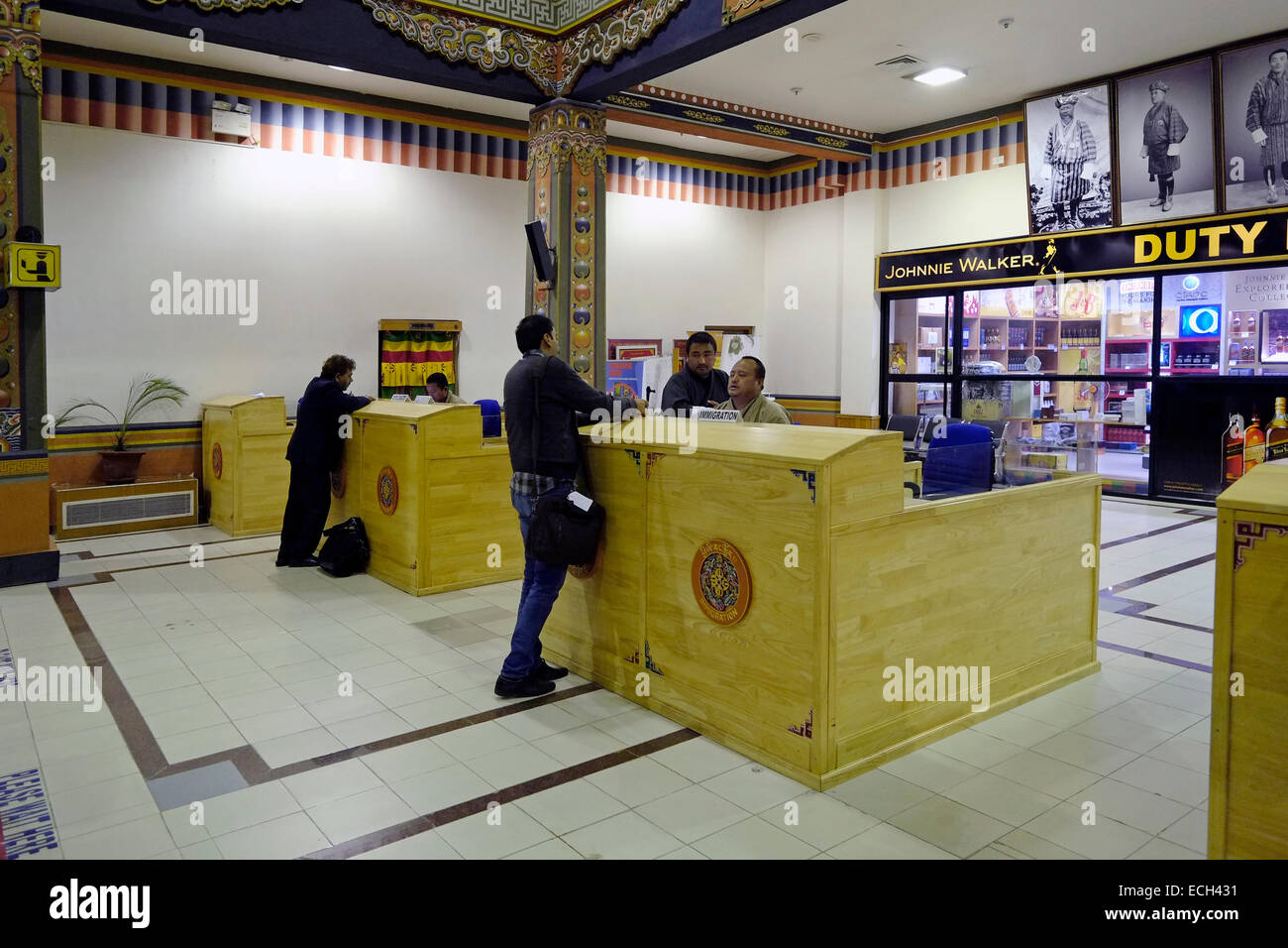 Passengers going through passport control desks at the arrival hall of ...