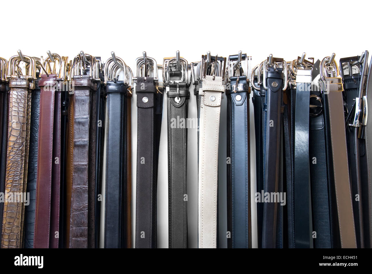 a lot of leather belts in store isolated on white Stock Photo - Alamy