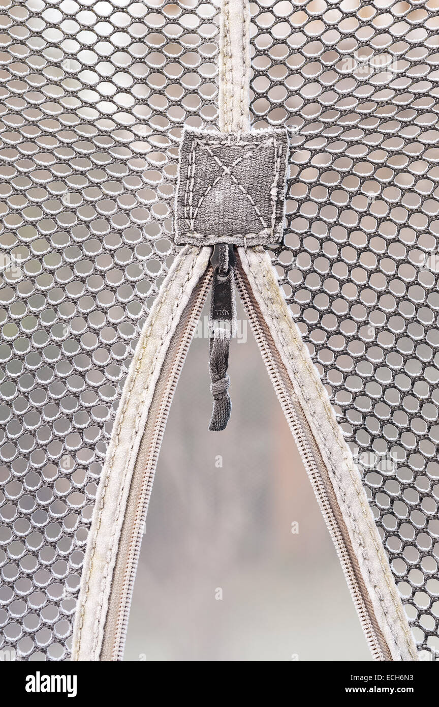 Frozen zip and open entrance to trampoline with netting covered in hard ...