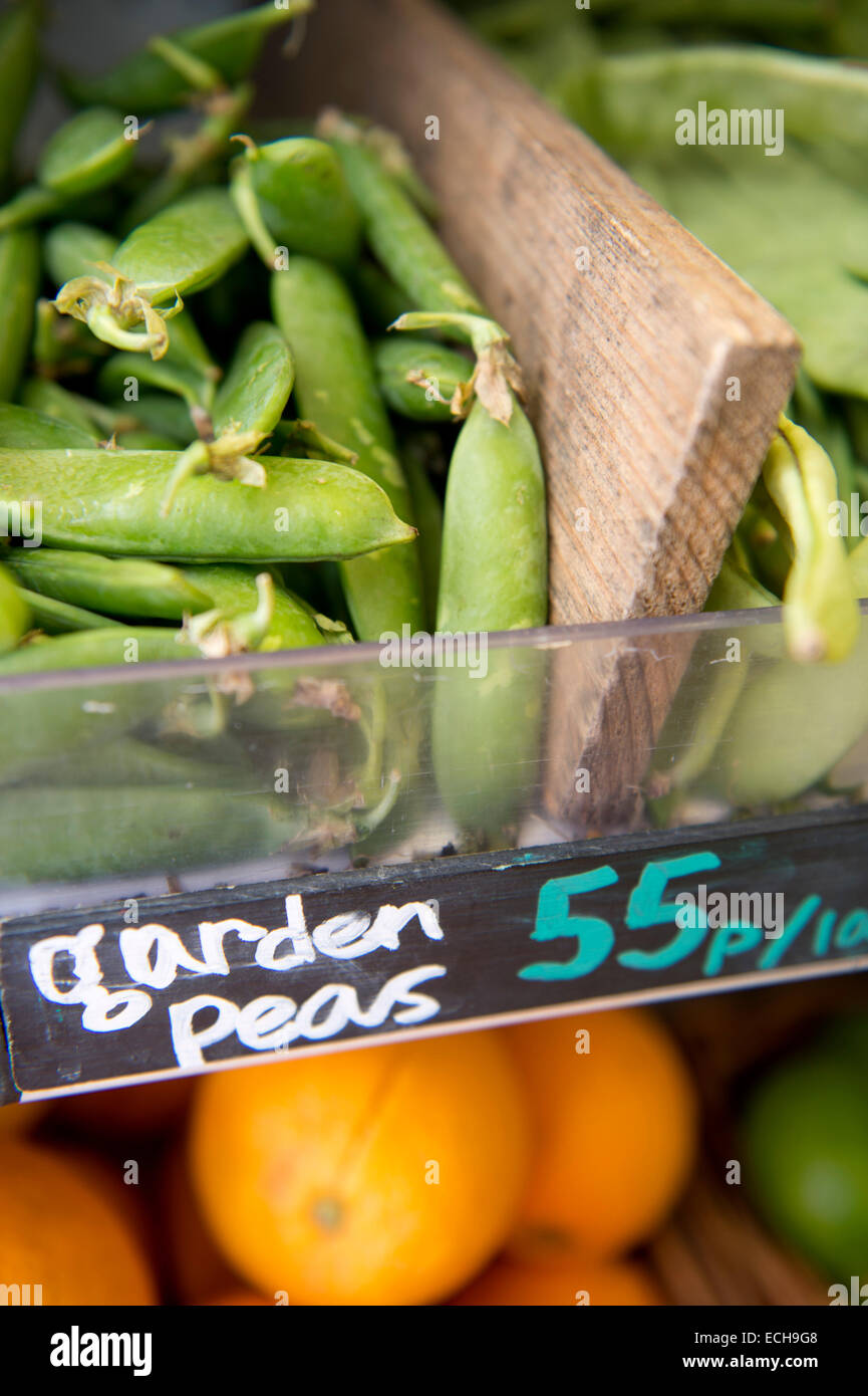 locally grown garden peas with imported fruit in an organic supermarket ...