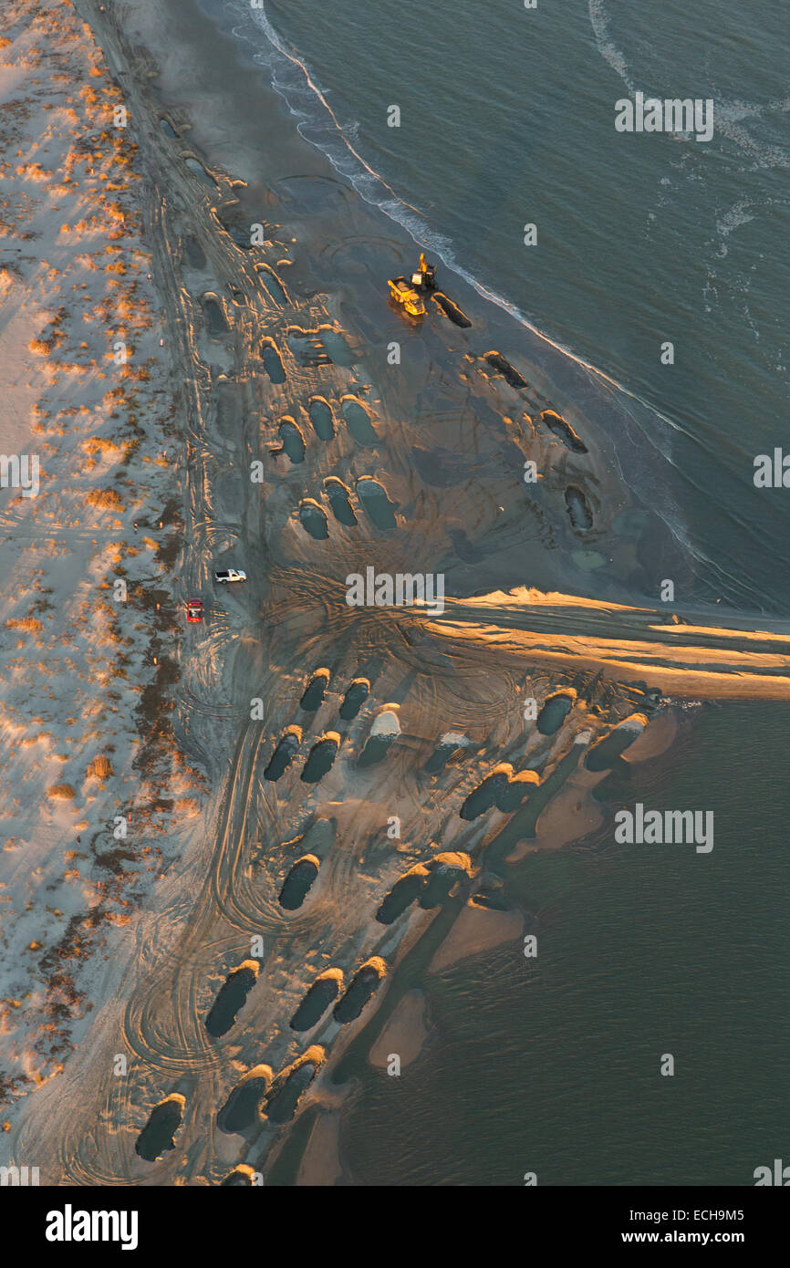 Aerial view of giant holes in the sand during a beach restoration ...