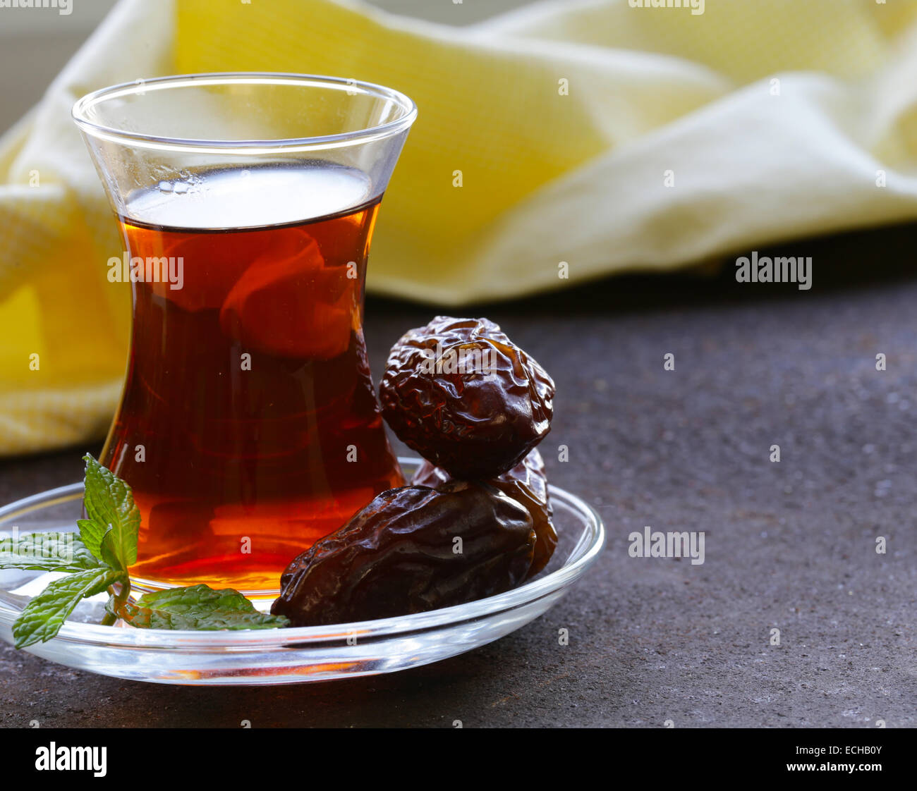 Turkish tea in traditional glass with sweet dates Stock Photo - Alamy