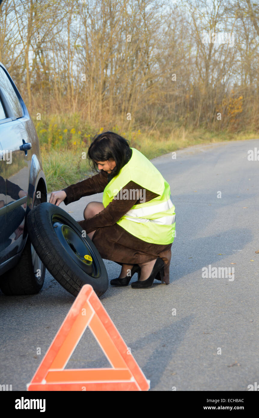 a photo of a woman with a broken wheel in the car Stock Photo - Alamy