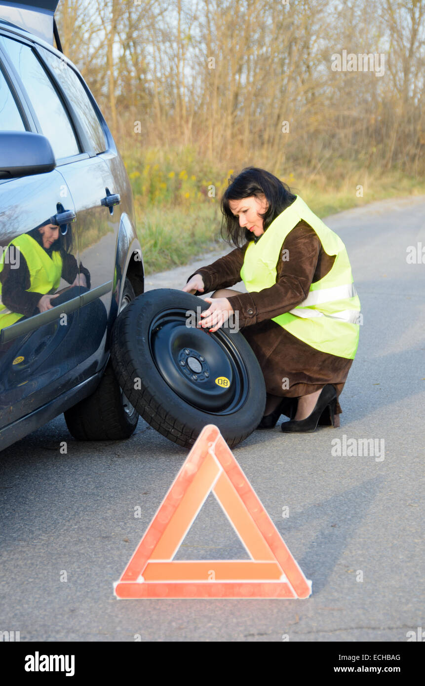 a photo of a woman with a broken wheel in the car Stock Photo - Alamy