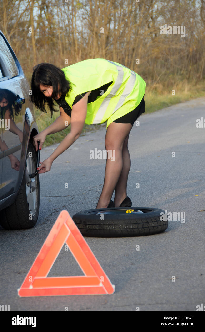 a photo of a woman with a broken wheel in the car Stock Photo - Alamy