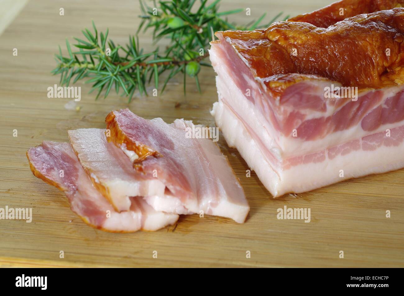 smoked bacon with juniper on chopping board Stock Photo - Alamy
