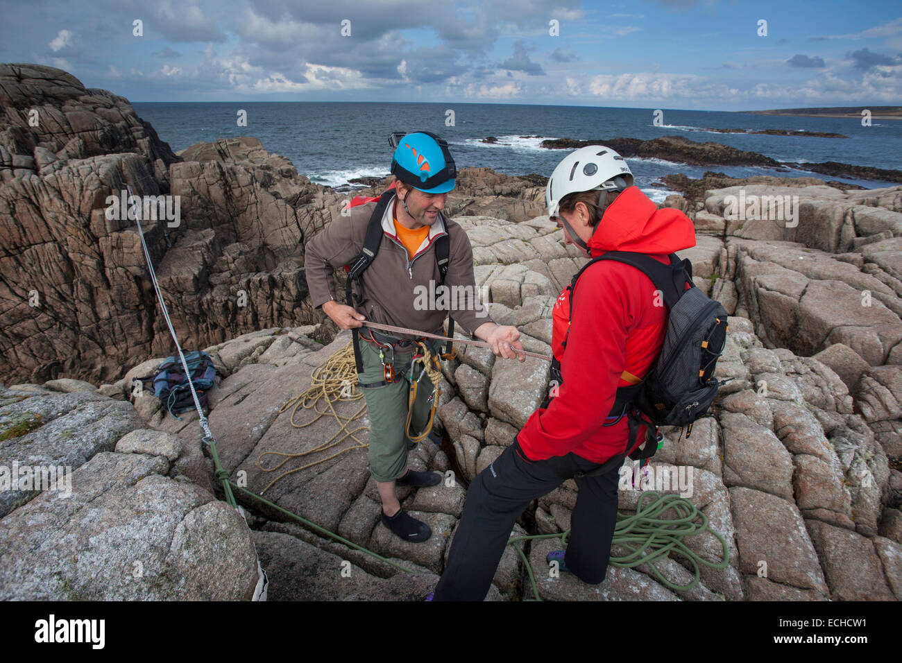 Rock climbers preparing the ropes for a tyrolean traverse to access a ...
