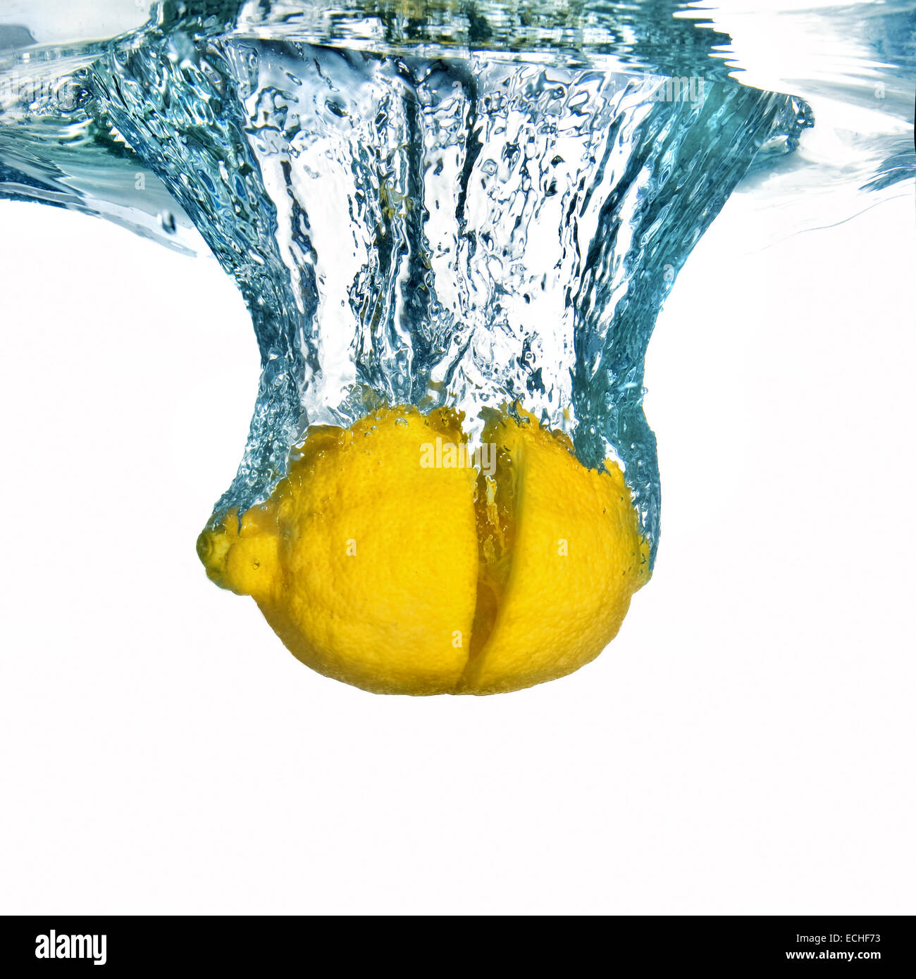Fresh lemon dropped into water with bubbles isolated on white Stock ...