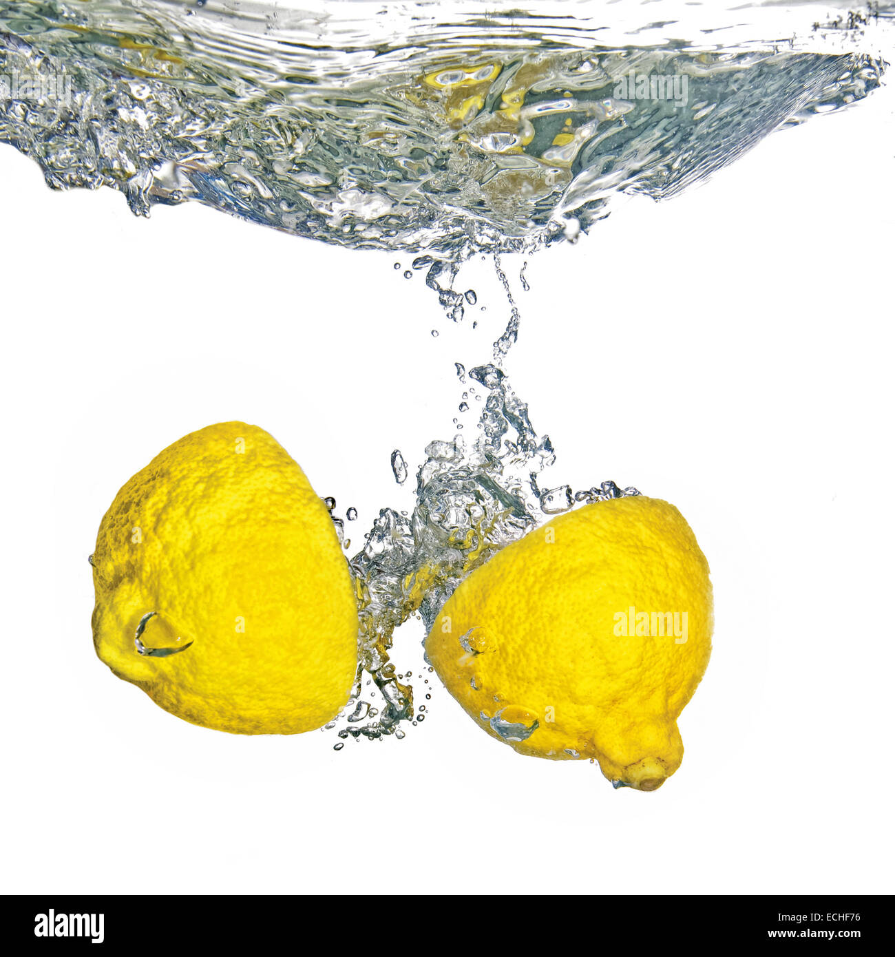 Fresh lemon dropped into water with bubbles isolated on white Stock ...