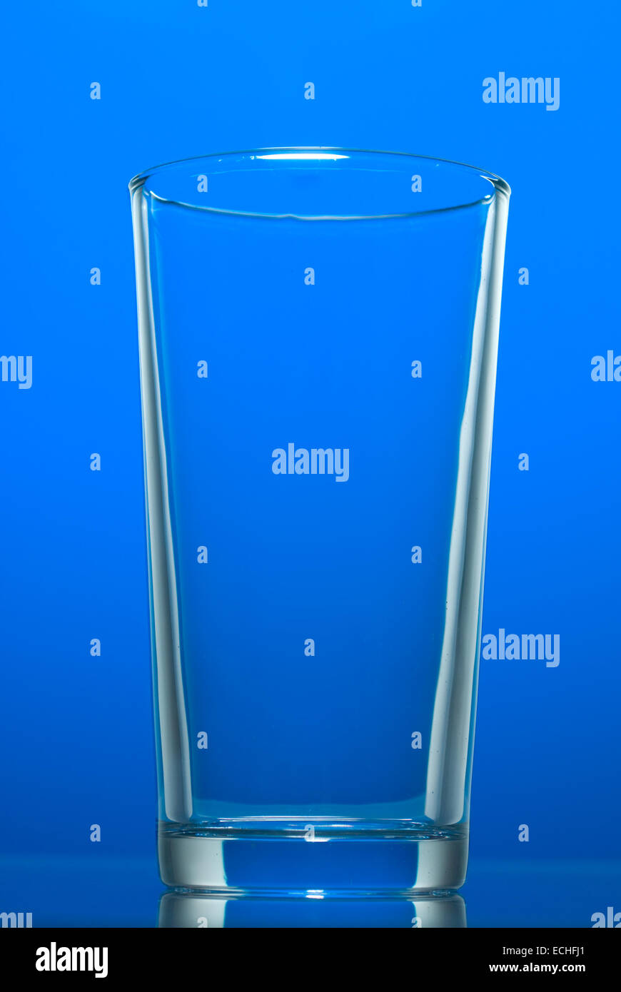 Empty glass isolated on blue Stock Photo - Alamy