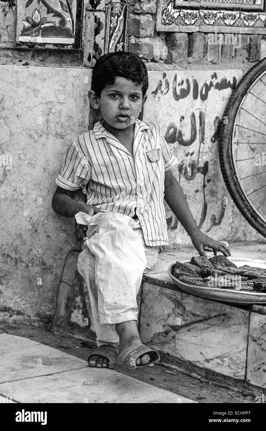 Young Iraqi boy selling sweets on the streets of Baghdad, Iraq. After ...