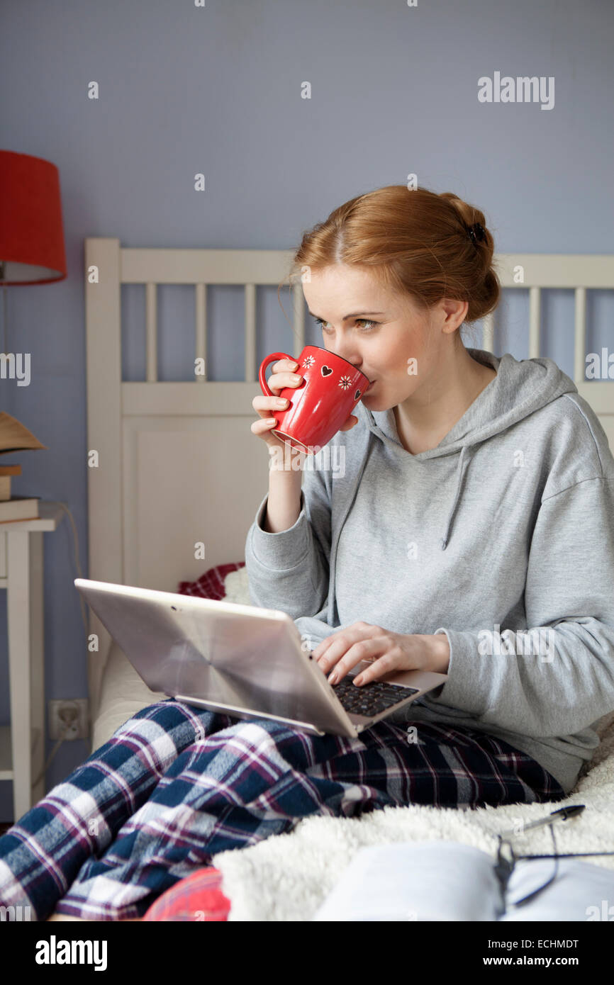 Young woman with laptop drinking coffee Stock Photo - Alamy