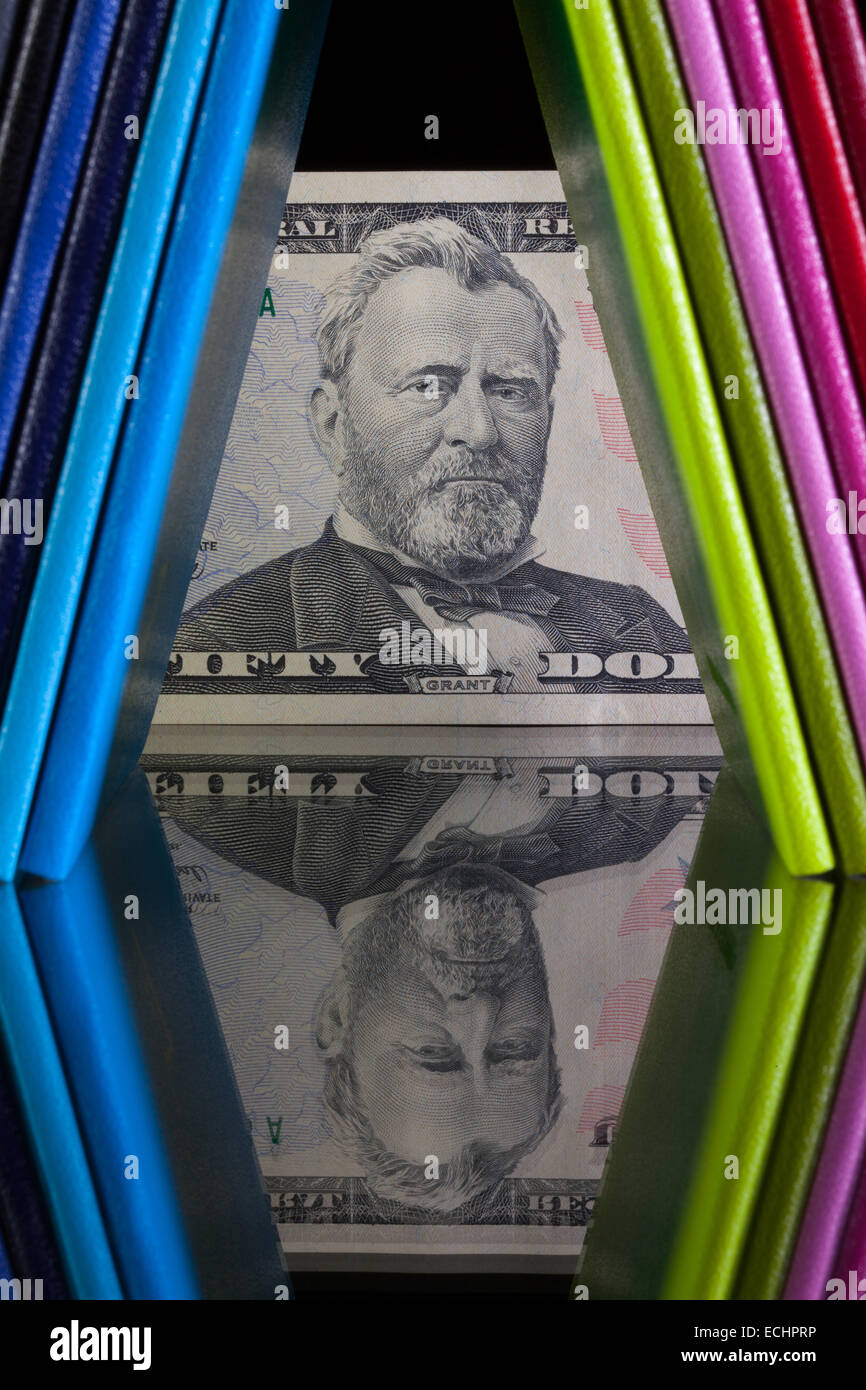 Twelve different colors diaries and US dollar banknote on a glass desk ...