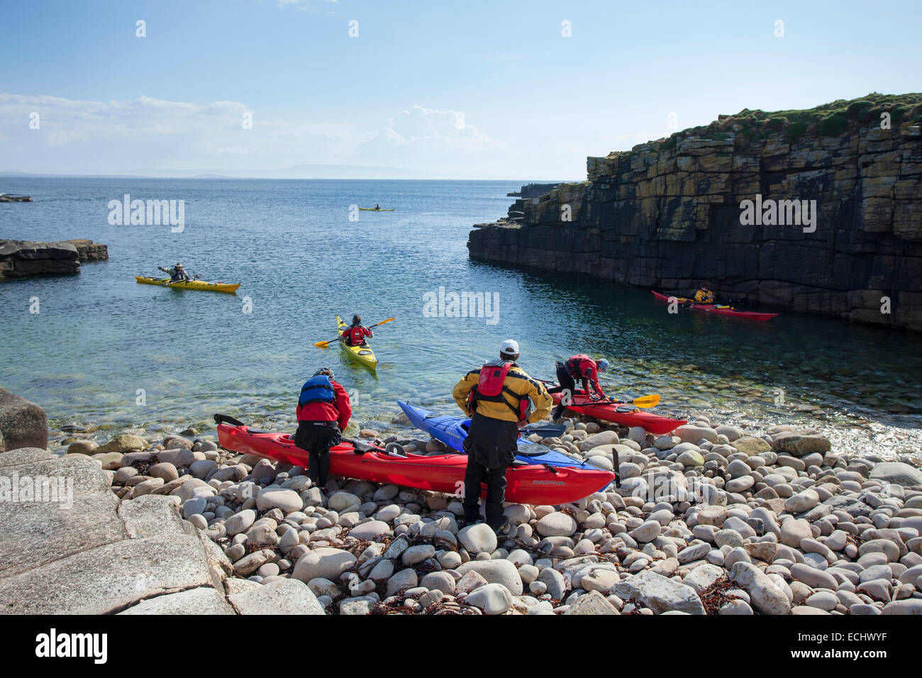 Sea kayakers launching from a rocky bay on Inishmurray Island, County ...