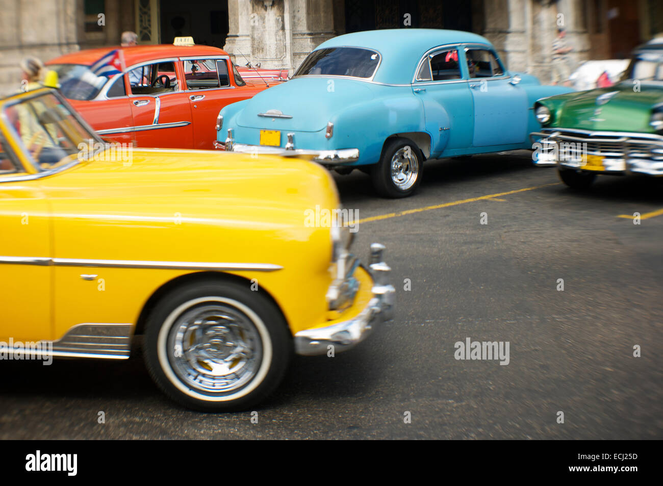 Tilt shift view of vintage American car passing others parked on Havana ...