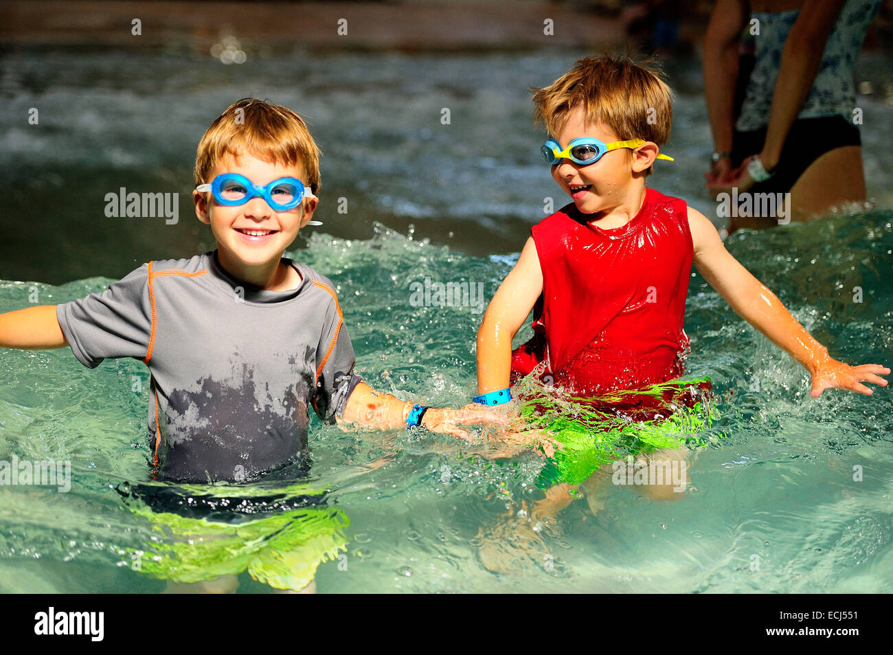 Two boys are having fun playing in a swimming pool Stock Photo - Alamy
