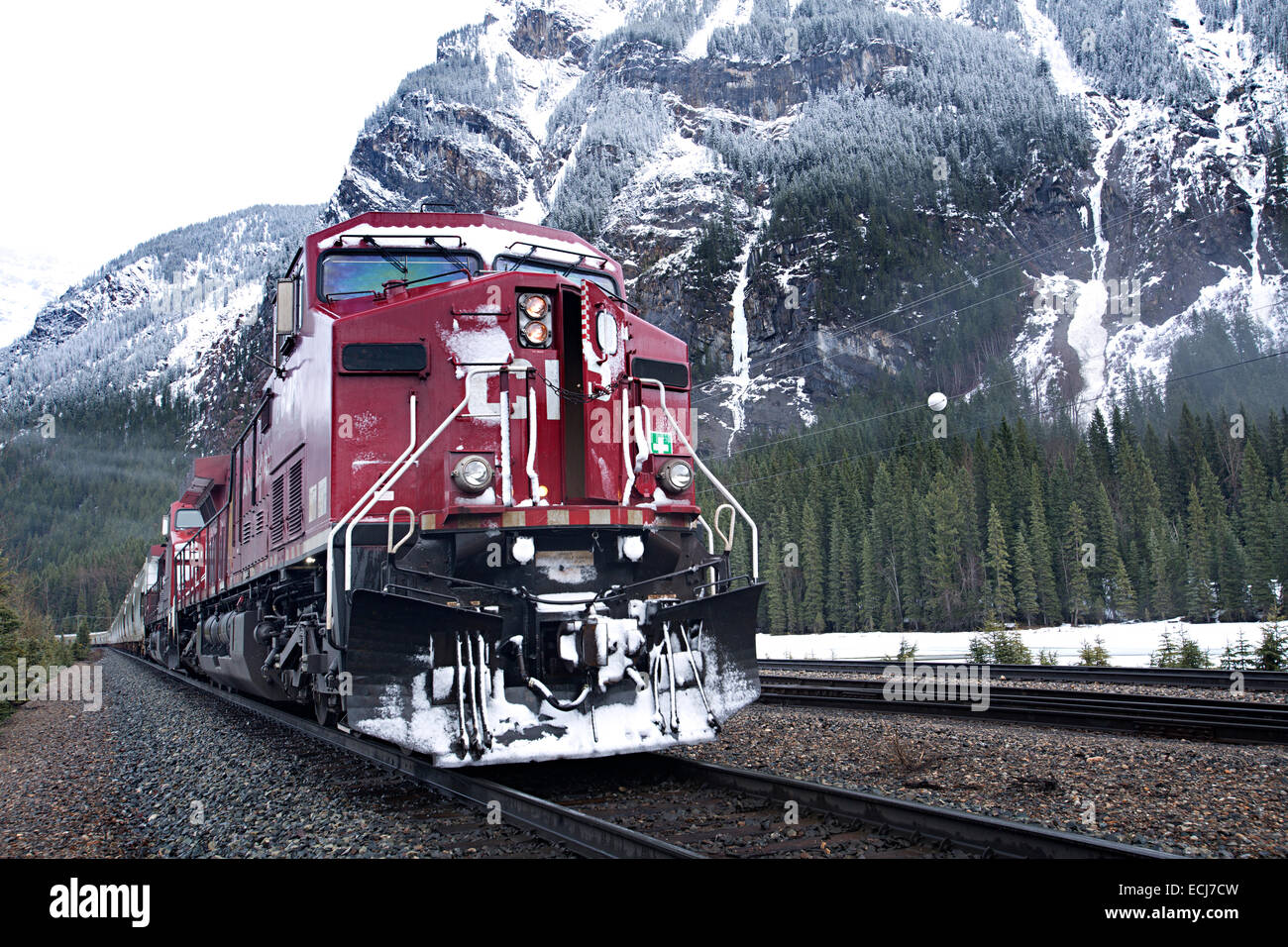 Red train covered with ice stopped beside snowy mountains Stock Photo ...