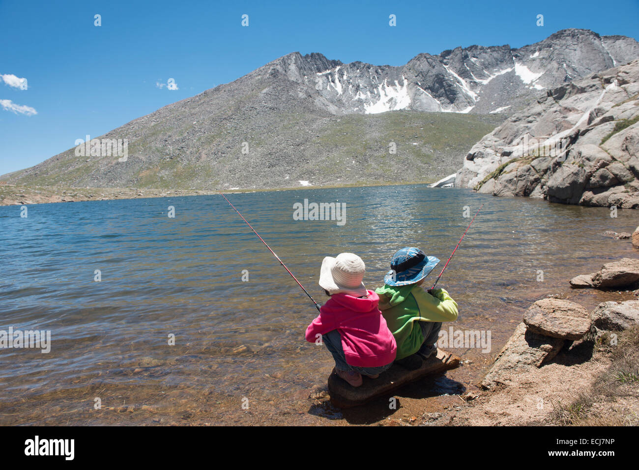 Boy-girl twins fishing in a high alpine lake on a 14,000 foot peak ...