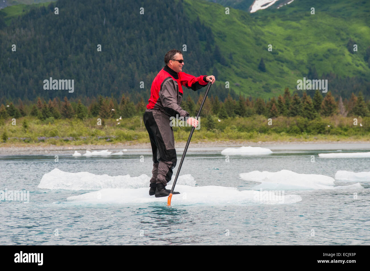 Man in drysuit paddles iceberg down tributary river next to Bear Lake ...