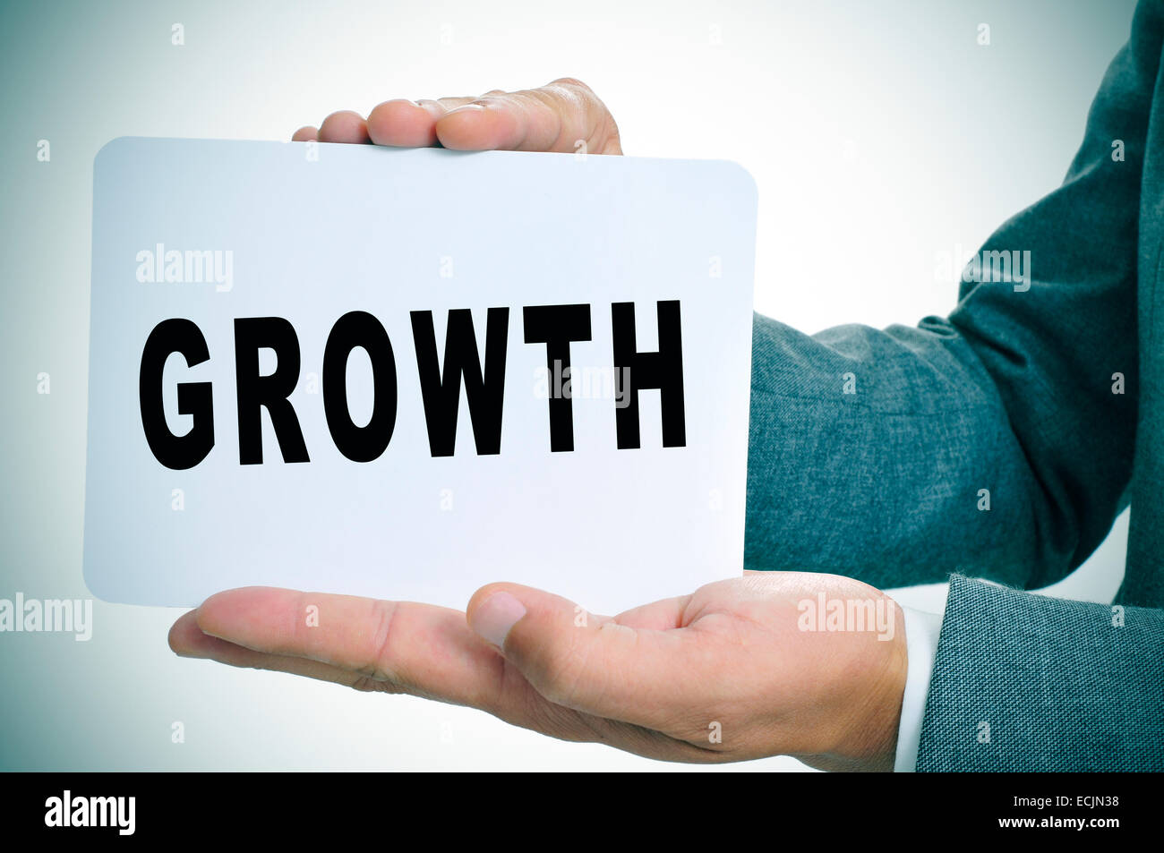 a young businessman showing a signboard with the text growth written in ...