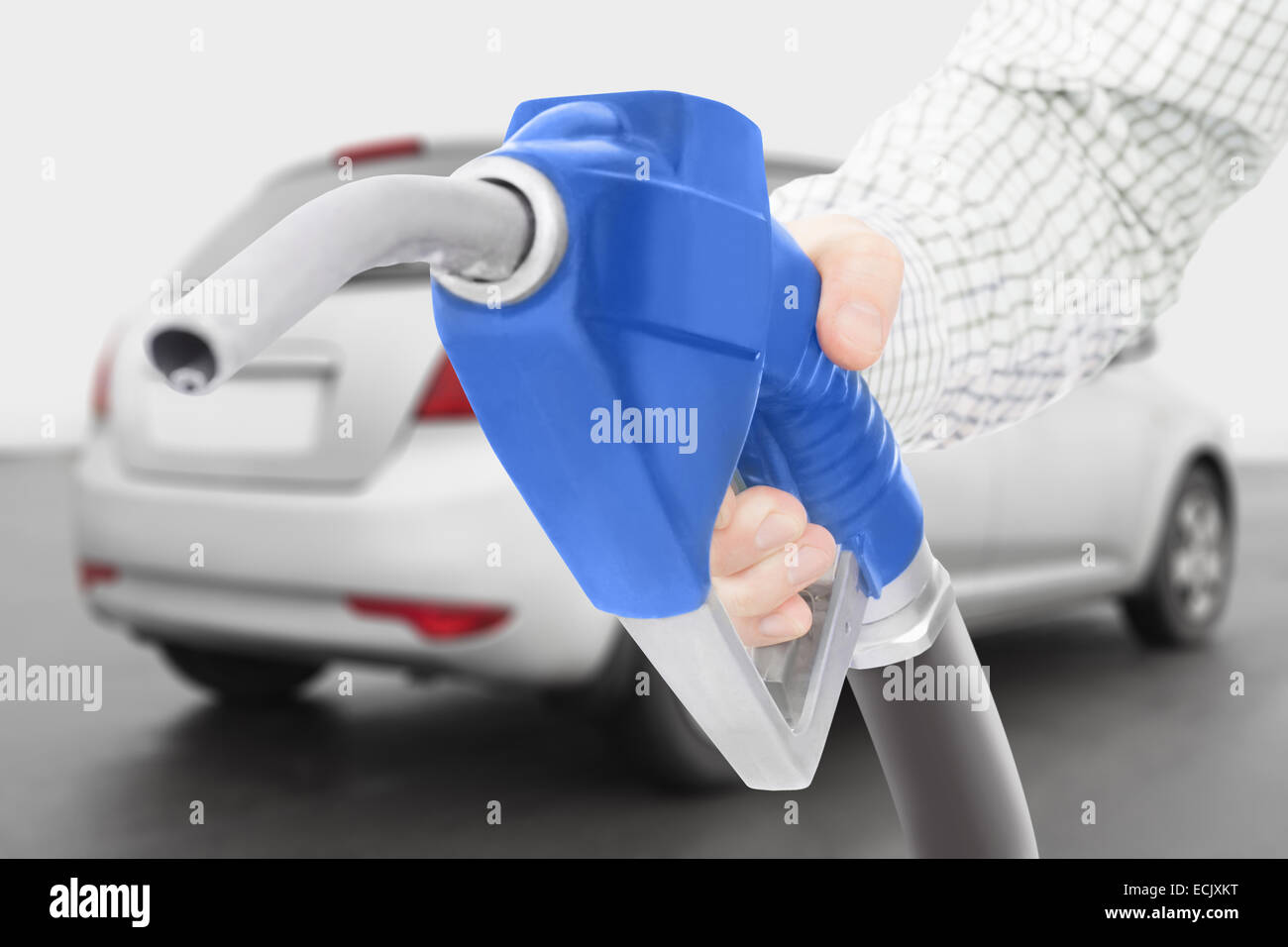 Blue color fuel pump gun with car on background Stock Photo - Alamy