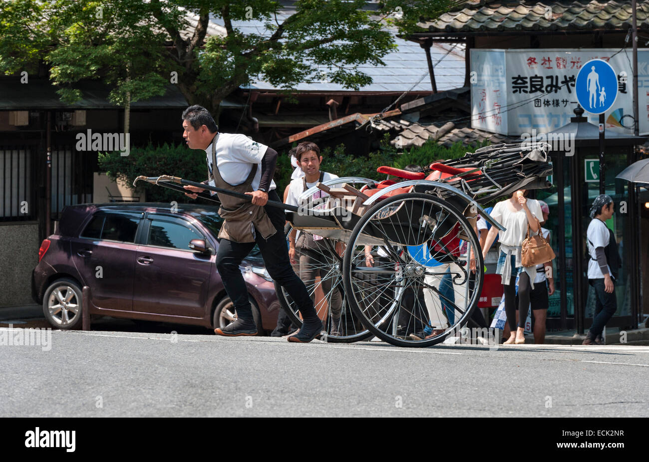 Nara, Japan. Tourists riding in rickshaws. The rickshaw-pullers are ...