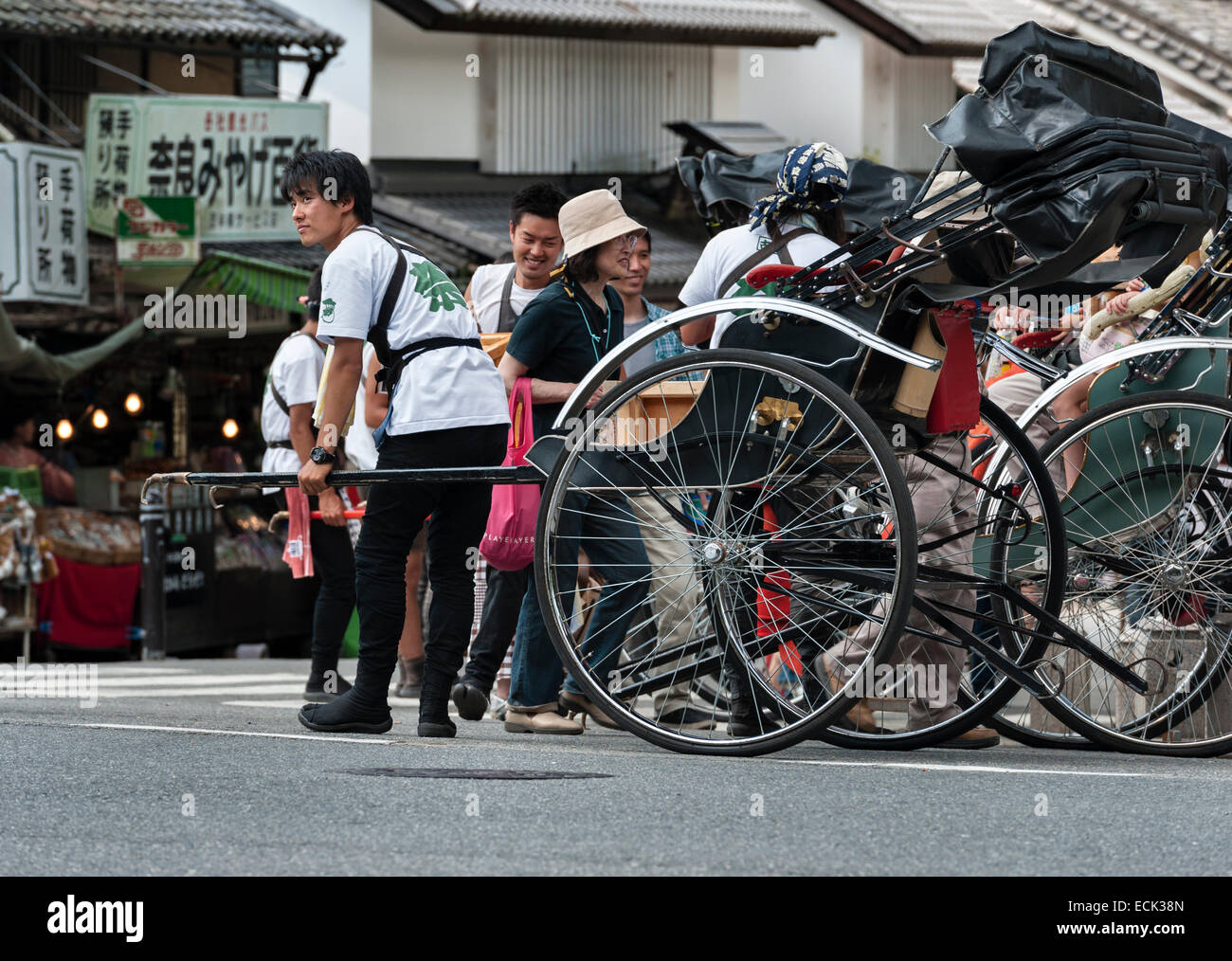 Nara, Japan. Tourists riding in rickshaws. The rickshaw-pullers are ...