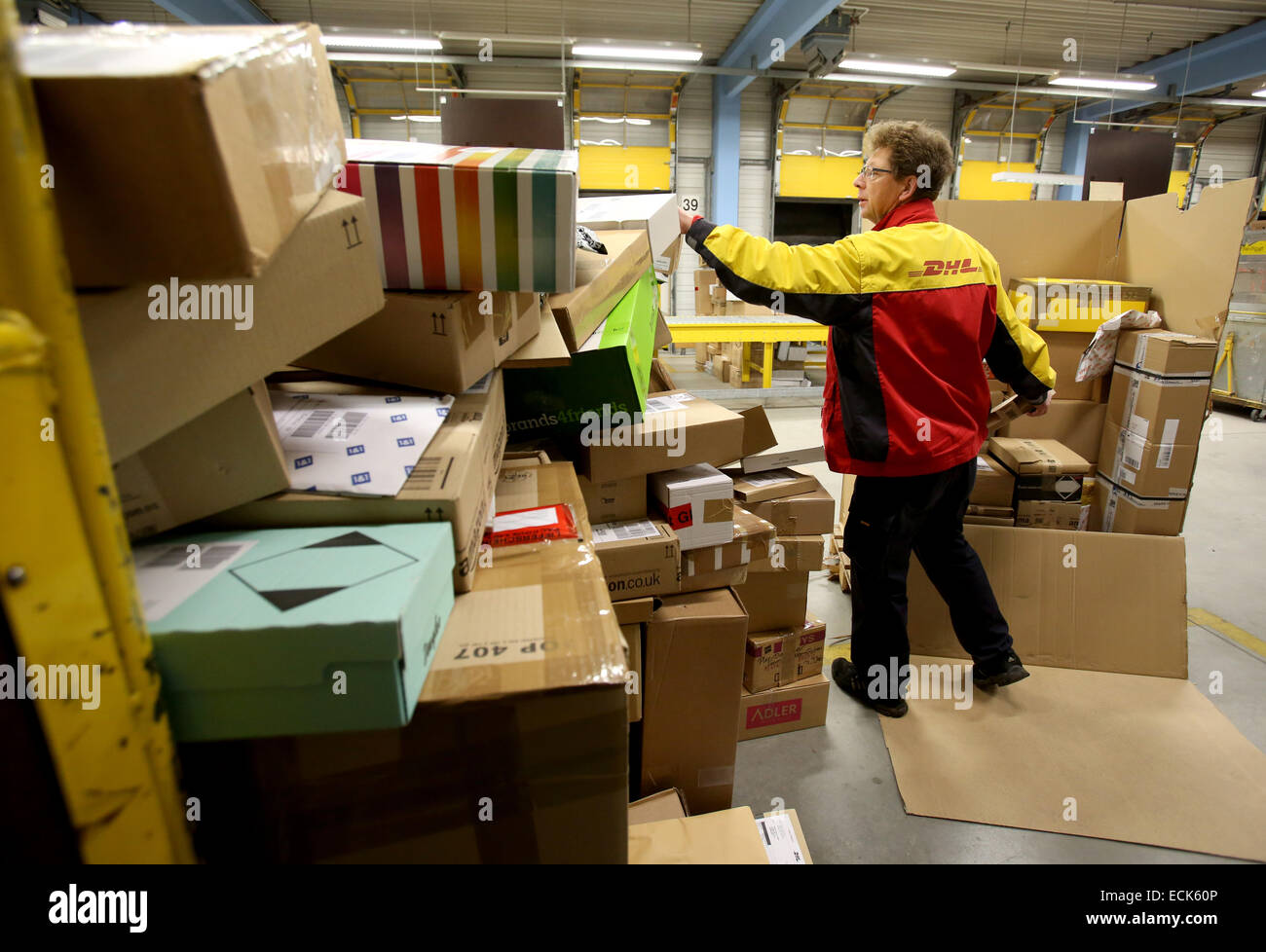 Staff member of 'Deutsche Post', German mail and parcel services, sorts ...