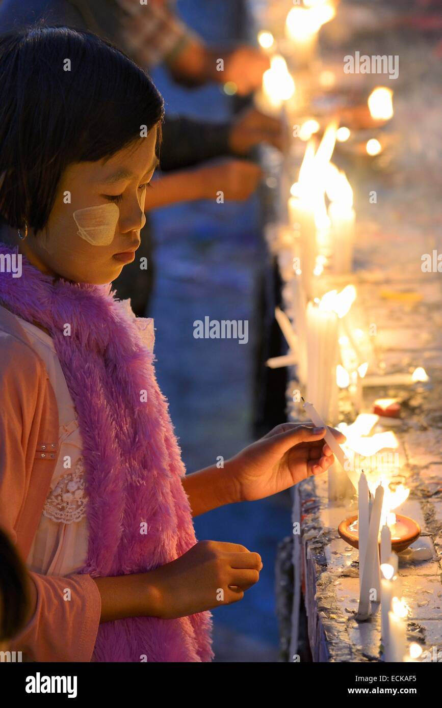 Myanmar (Burma), Mon State, Kyaiktiyo, Young buddhist devotee lighting ...