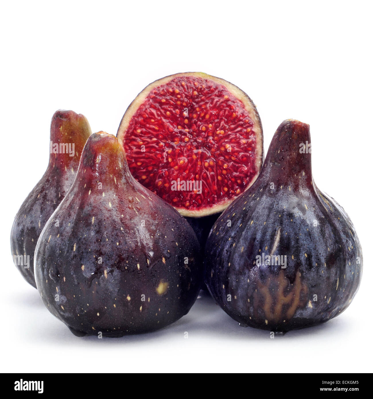 some figs, one of them cut in halves, on a white background Stock Photo ...